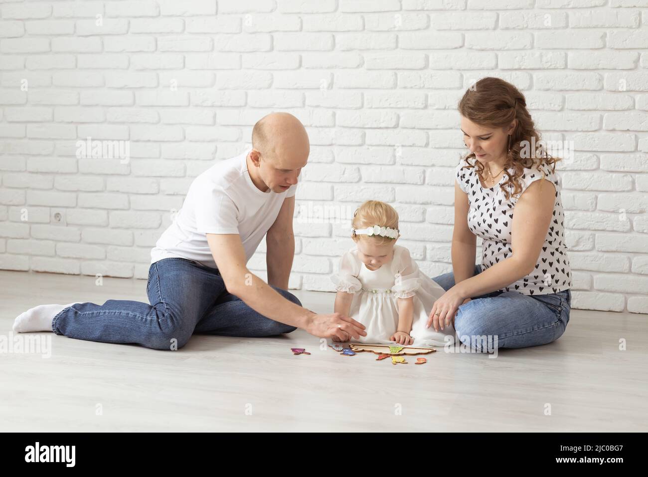 Baby child with hearing aids and cochlear implants plays with parents ...