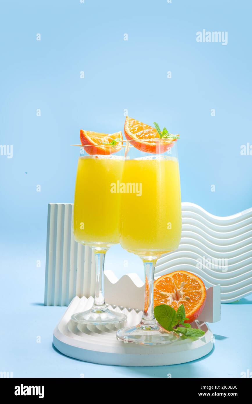 Classic summer mimosas cocktail, with orange juice, on light blue ...