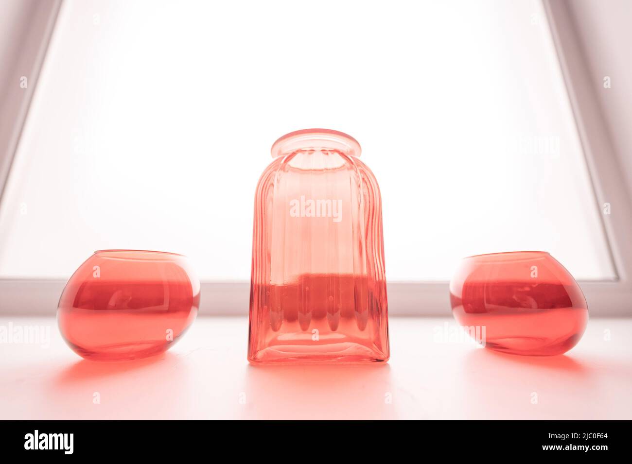 Three empty glass red vases on the windowsill Stock Photo - Alamy