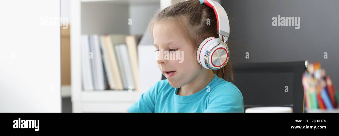Cute kid wearing headset and typing on keyboard with effort Stock Photo ...