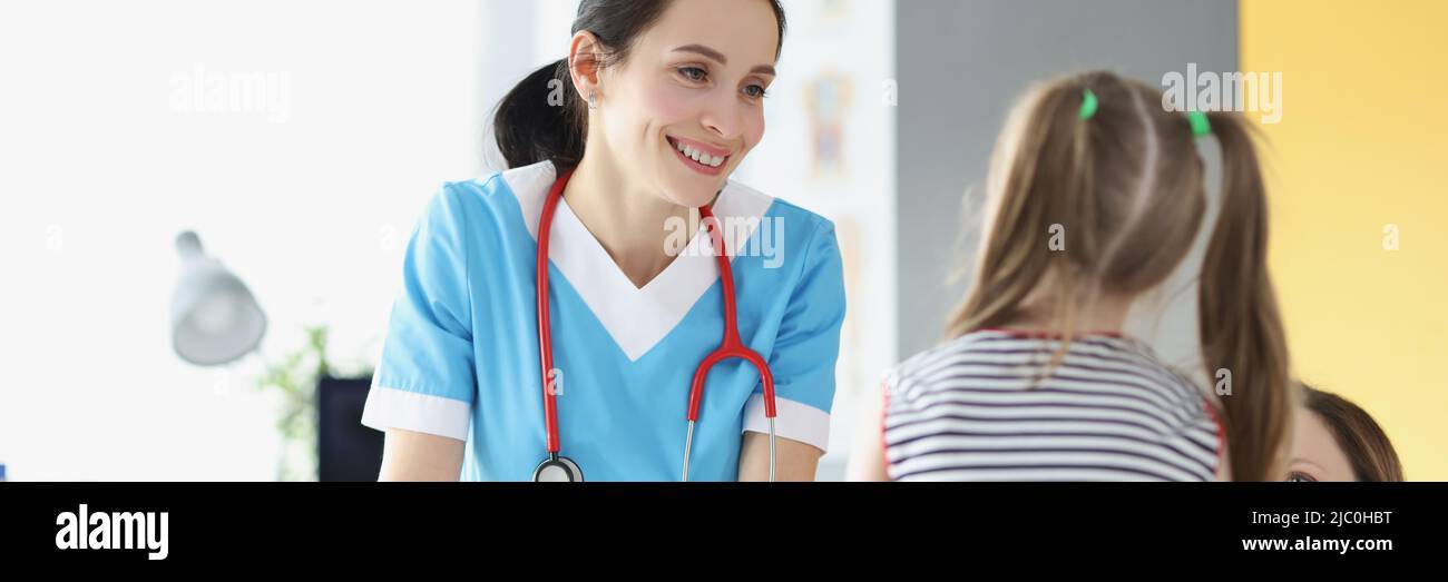 Smiling professional pediatrician talk to young cute patient girl on ...