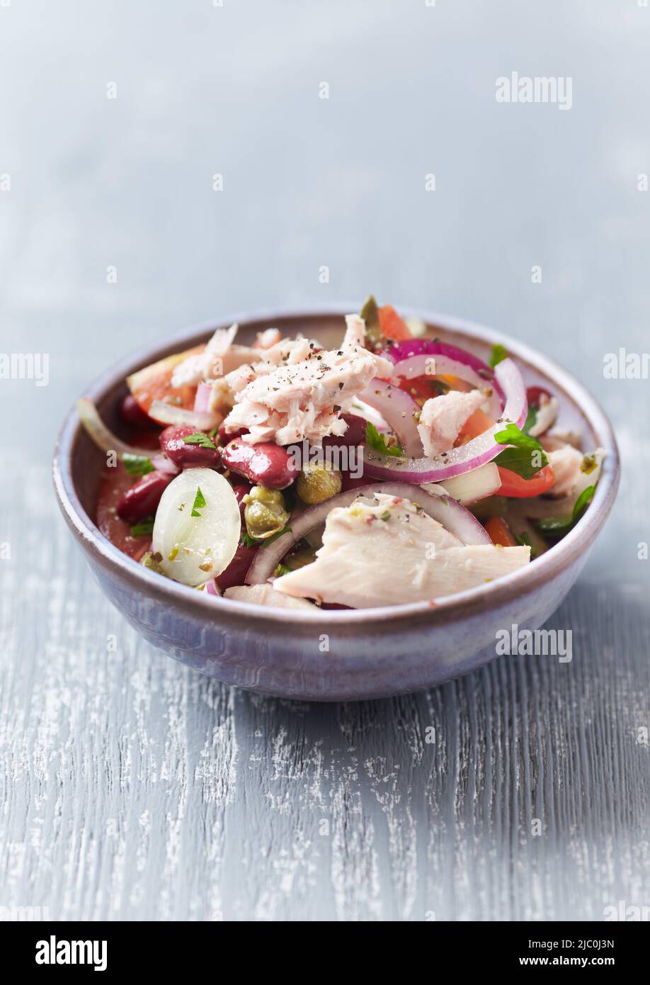 Salad with tuna and cherry tomatoes. Wooden background. Close up. Copy ...