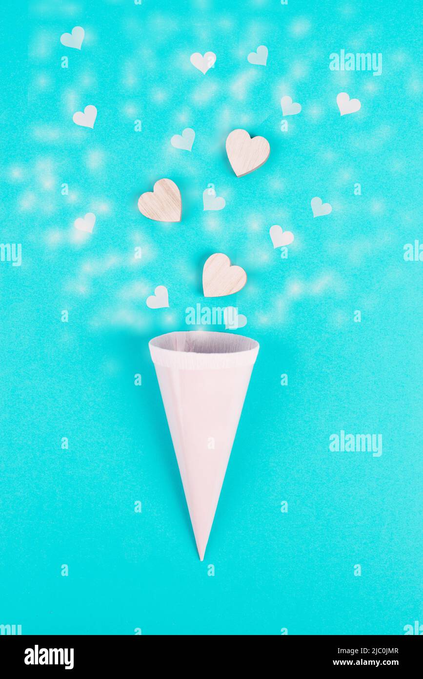 Cone with rose colored hearts, blue background, birthday and valentines ...