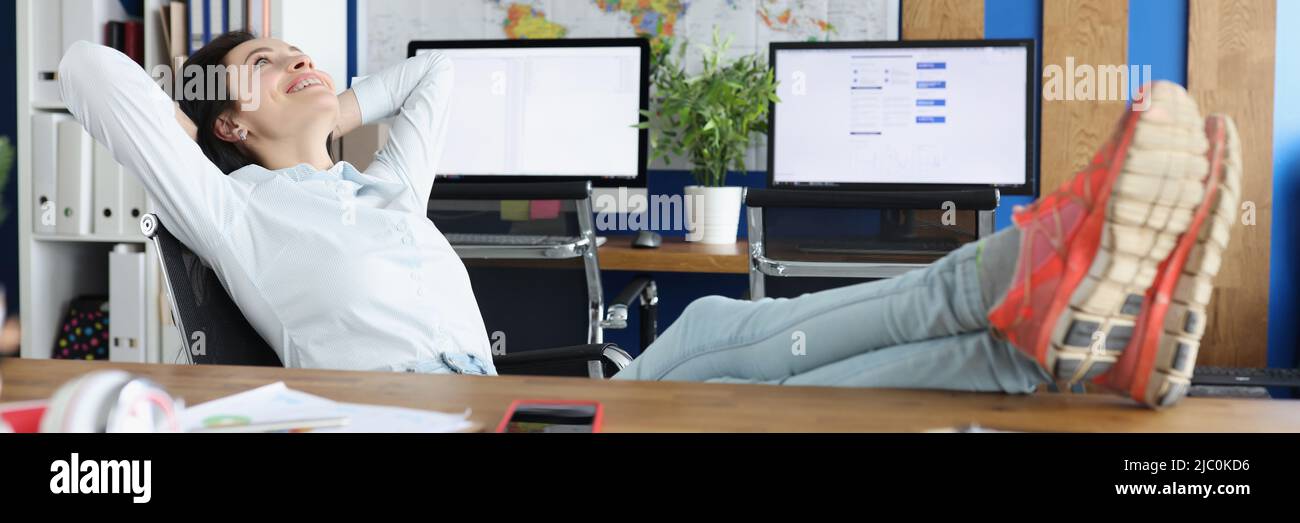 Female employee chilling and put legs on table after hard day at work ...