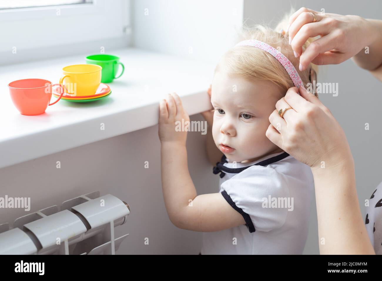 Mother fixing her daughter's cochlear implant hearing aid - deafness ...