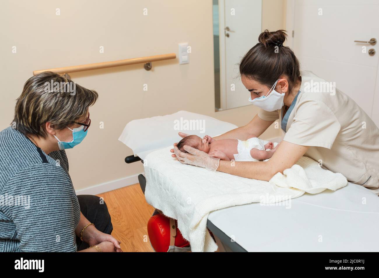 Female physiotherapist doing an extensor tone relaxation on a newborn ...