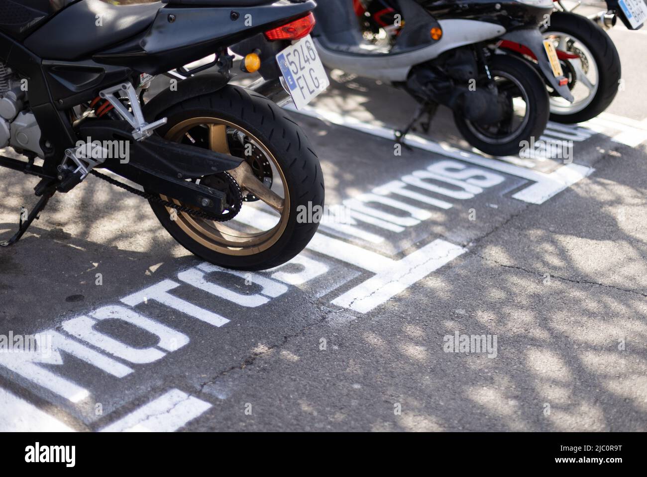 Motorbikes parked on a parking lot outside. Sign on the road Stock ...