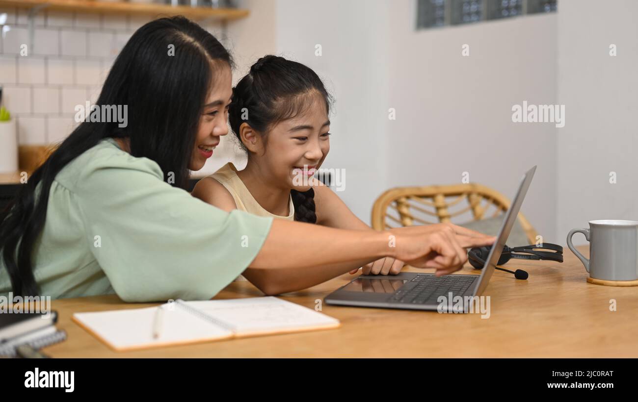 Cute asian girl with mother doing homework at home. Education and ...