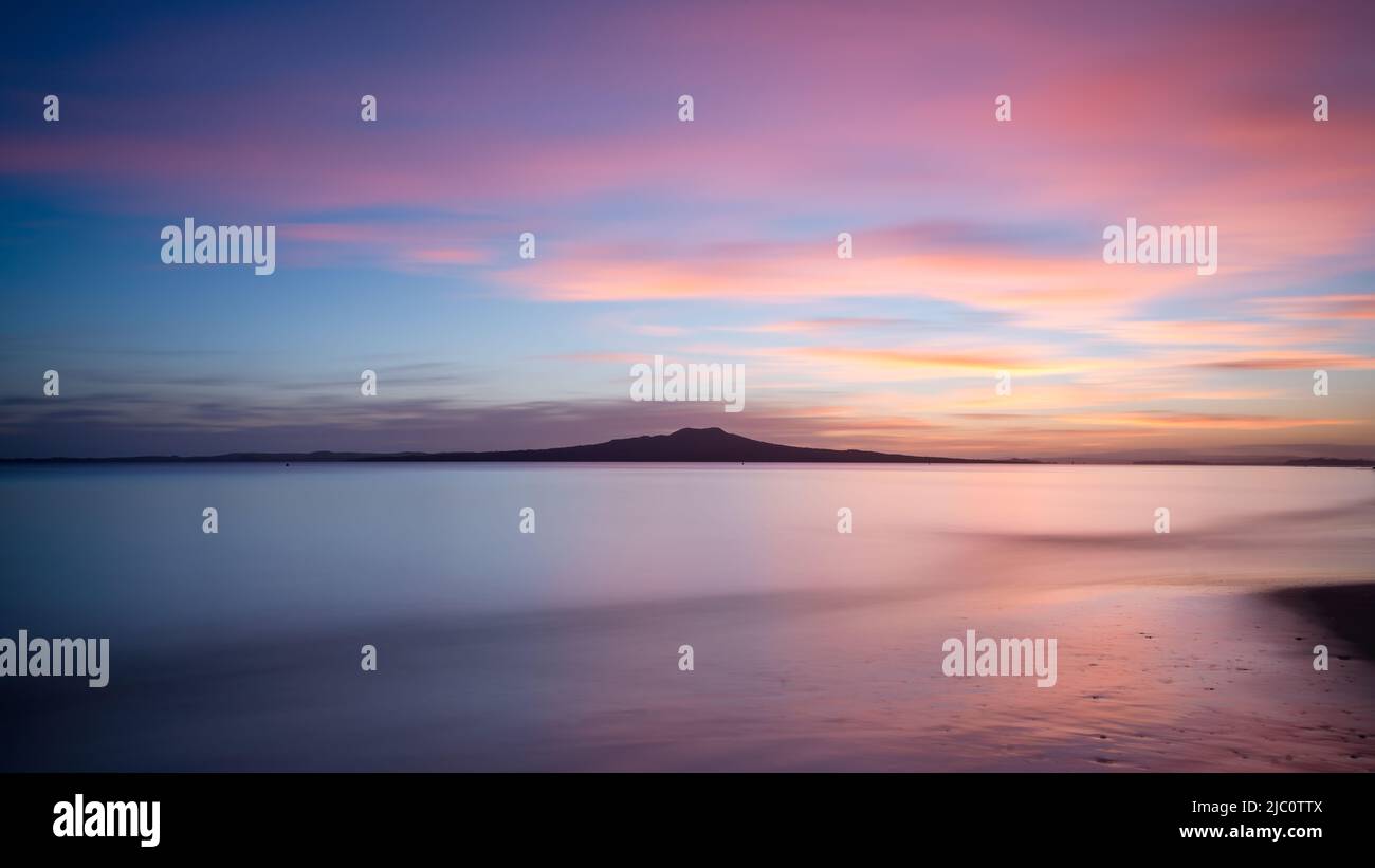 Milford Beach at dawn with Rangitoto Island in the distance, Auckland ...