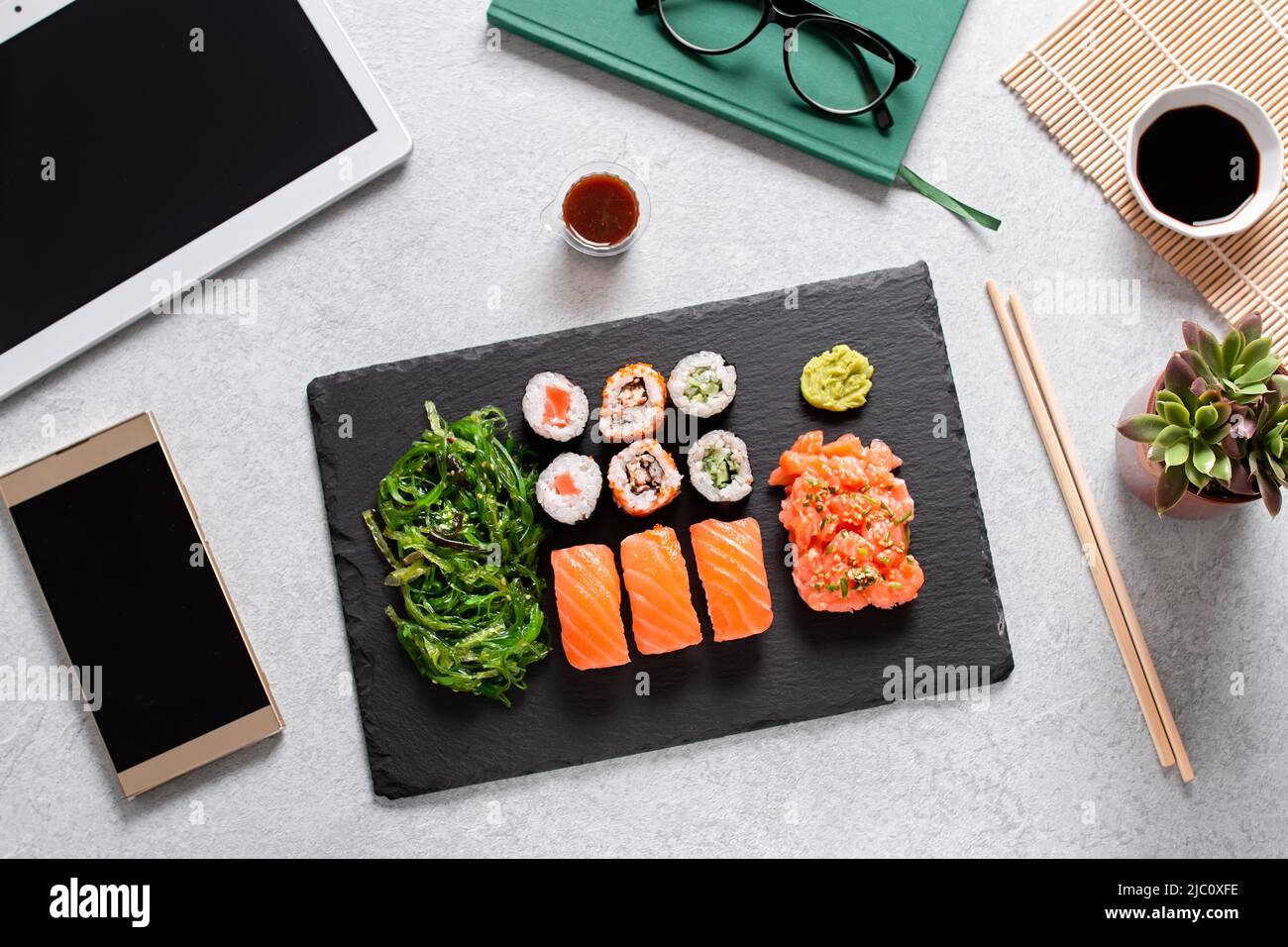Sushi takeaway at work desk overhead. Eating sushi for lunch break ...