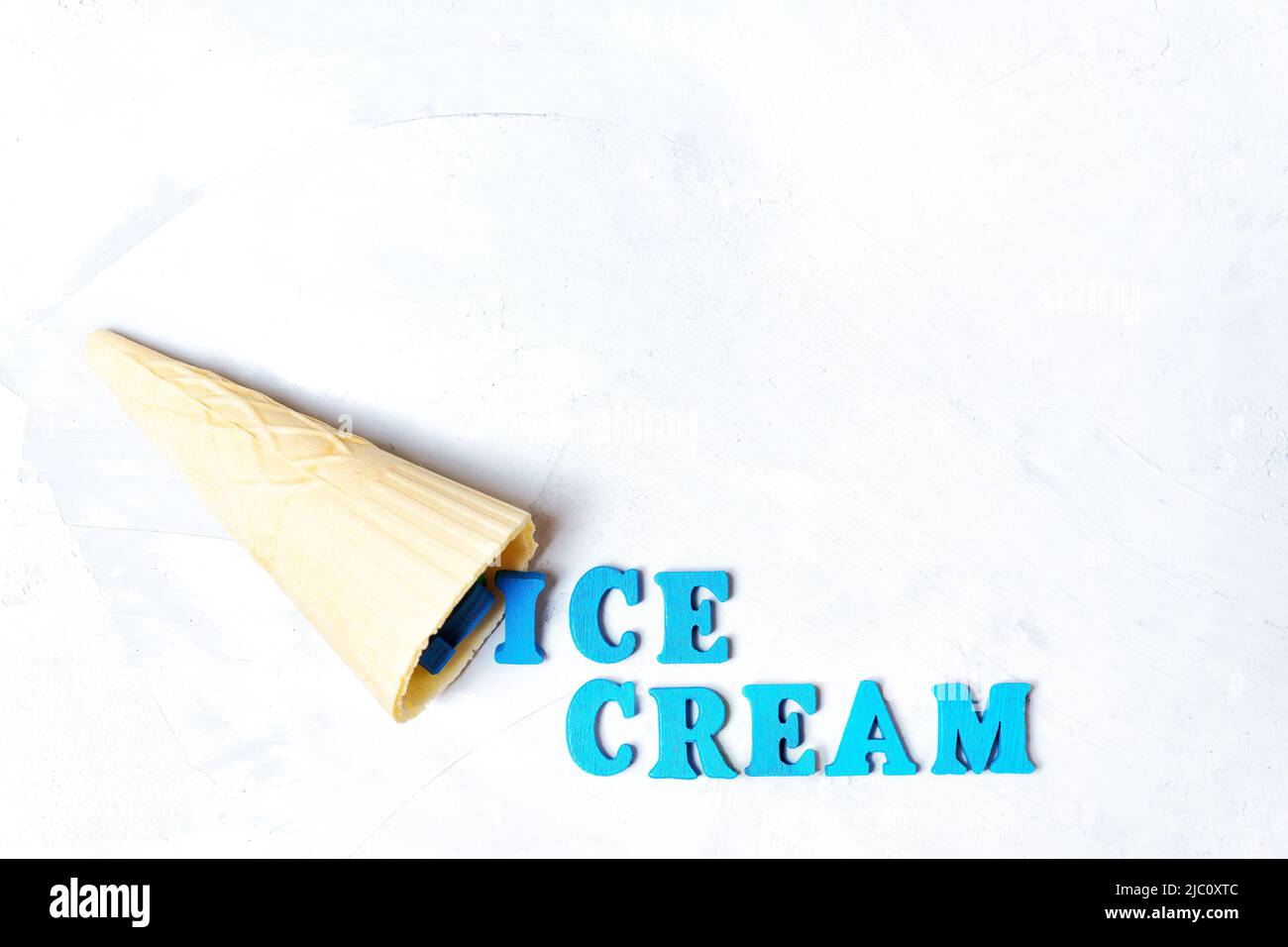 Waffle cone and ICE CREAM lettering on a concrete background with copy ...