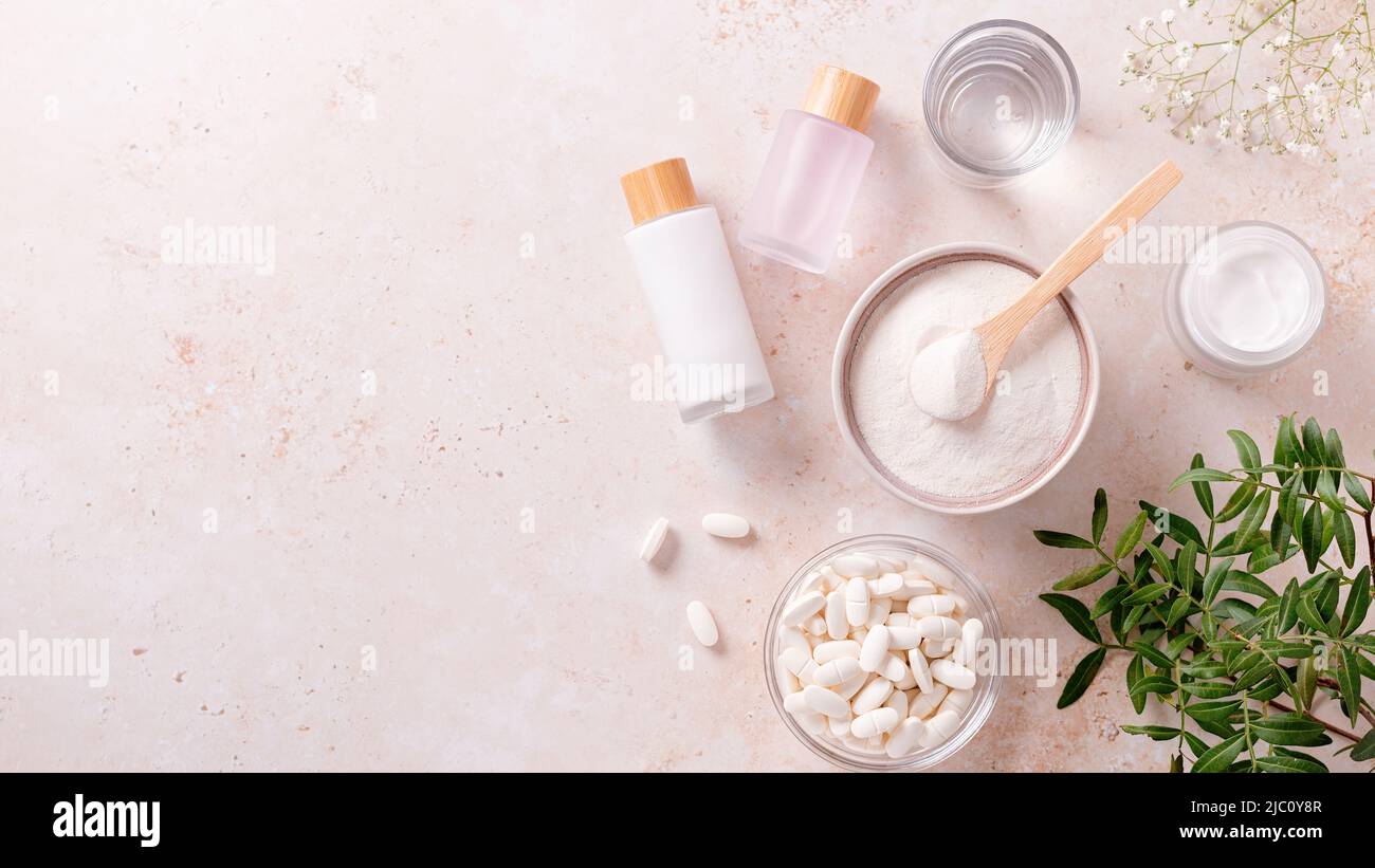 Collagen powder, collagen pills, facial cream and serum on top of stone ...