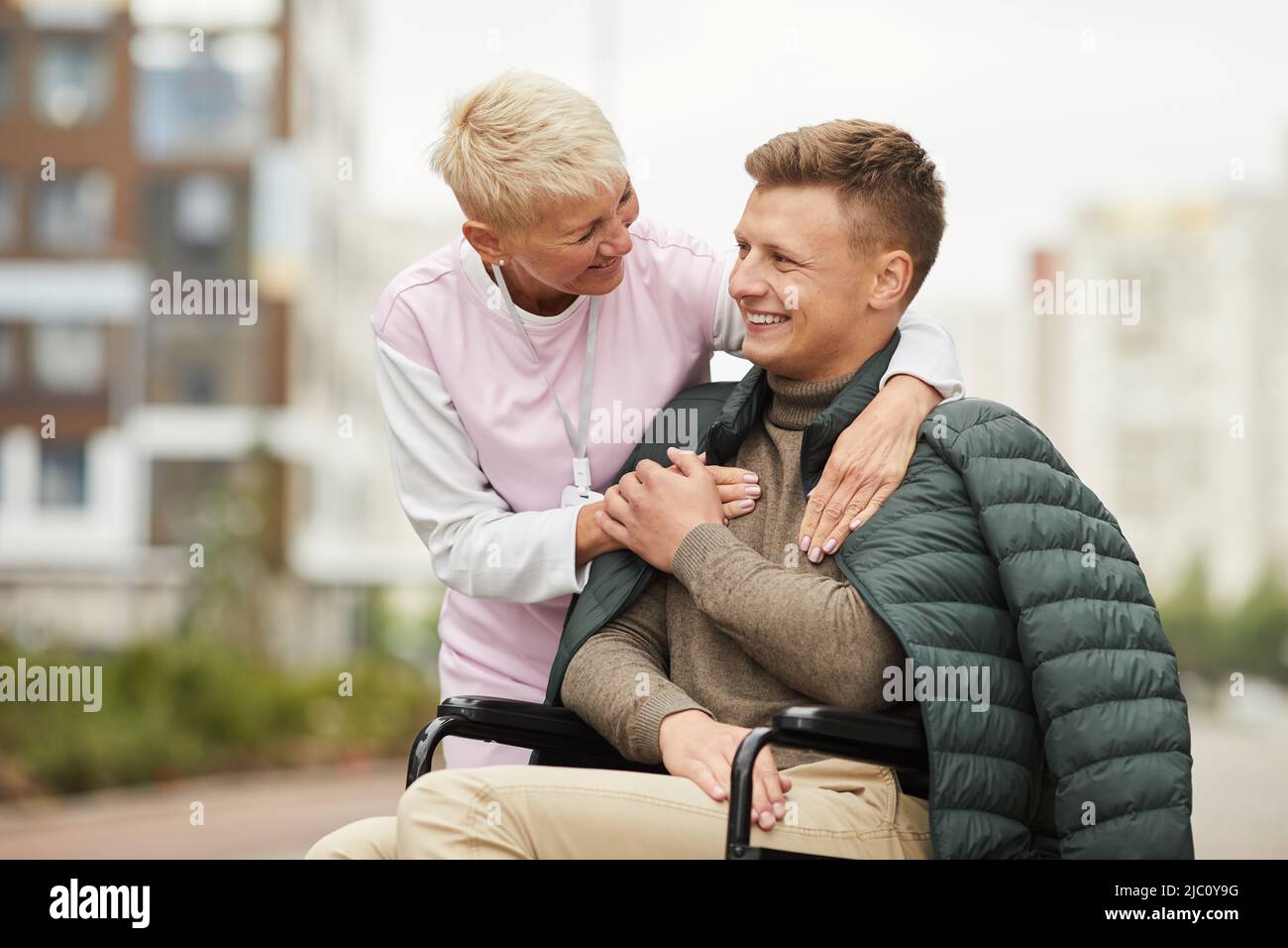 Cheerful careful mature medical specialist in uniform covering patient ...