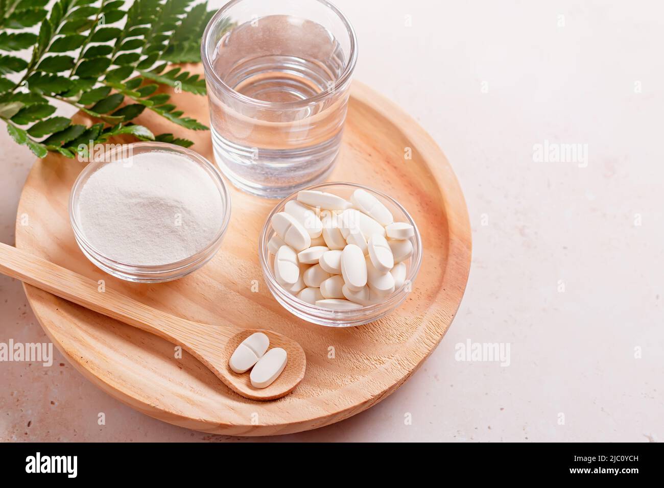 Collagen powder, glass of water and collagen pills on neutral beige ...