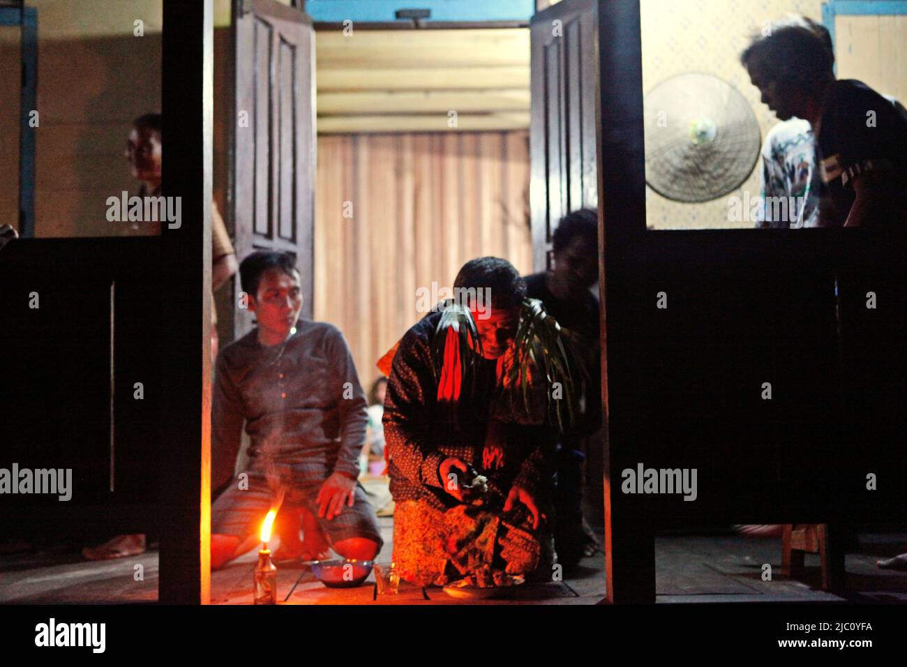 A witch doctor conducting a ritual on the porch of Dayak Iban's ...