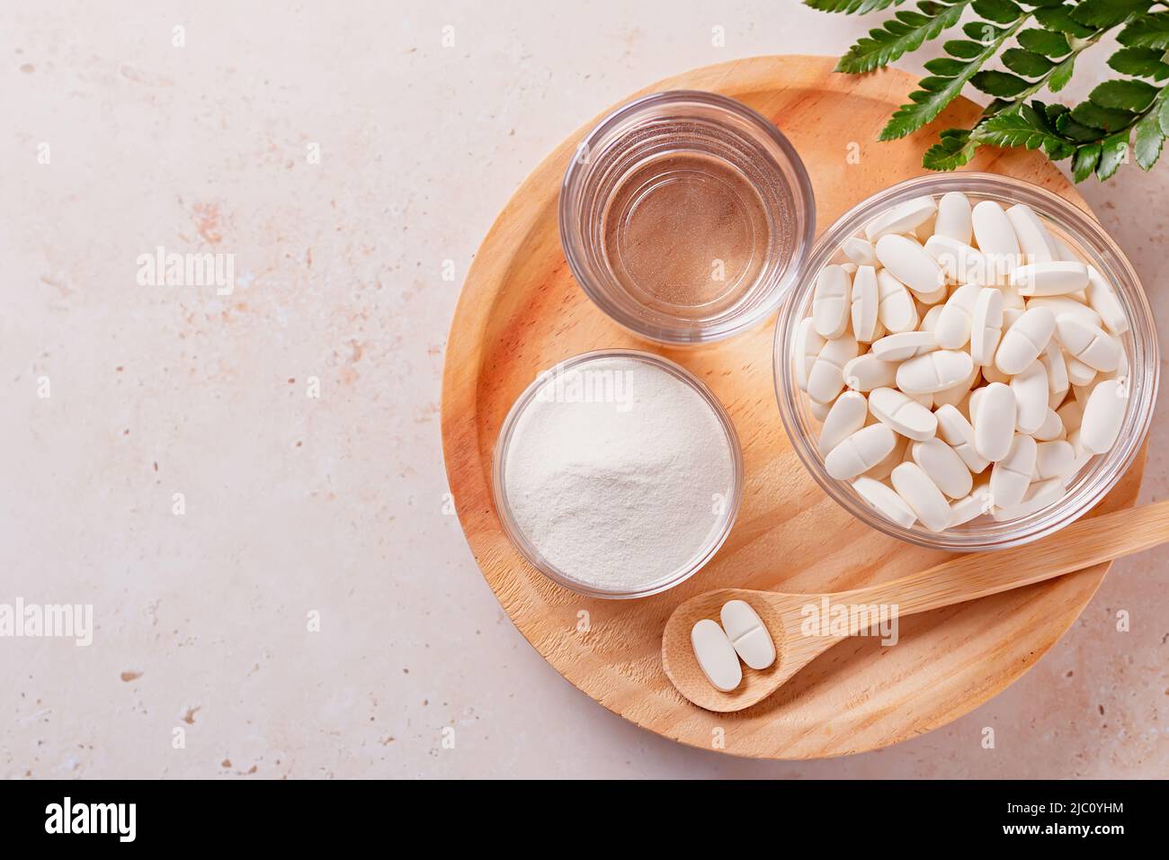 Collagen powder, glass of water and collagen pills on neutral beige ...