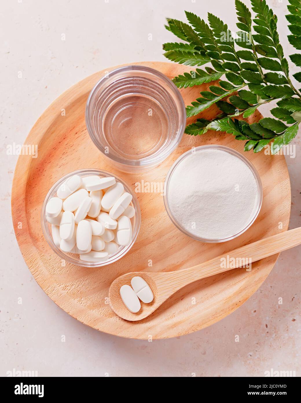 Collagen powder, glass of water and collagen pills on neutral beige ...