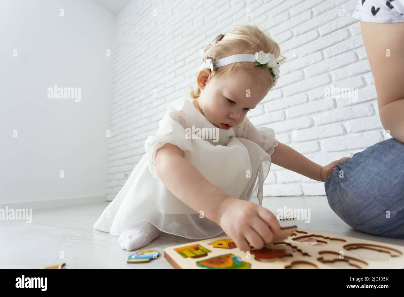 Baby child with hearing aids and cochlear implants plays on floor. Deaf ...