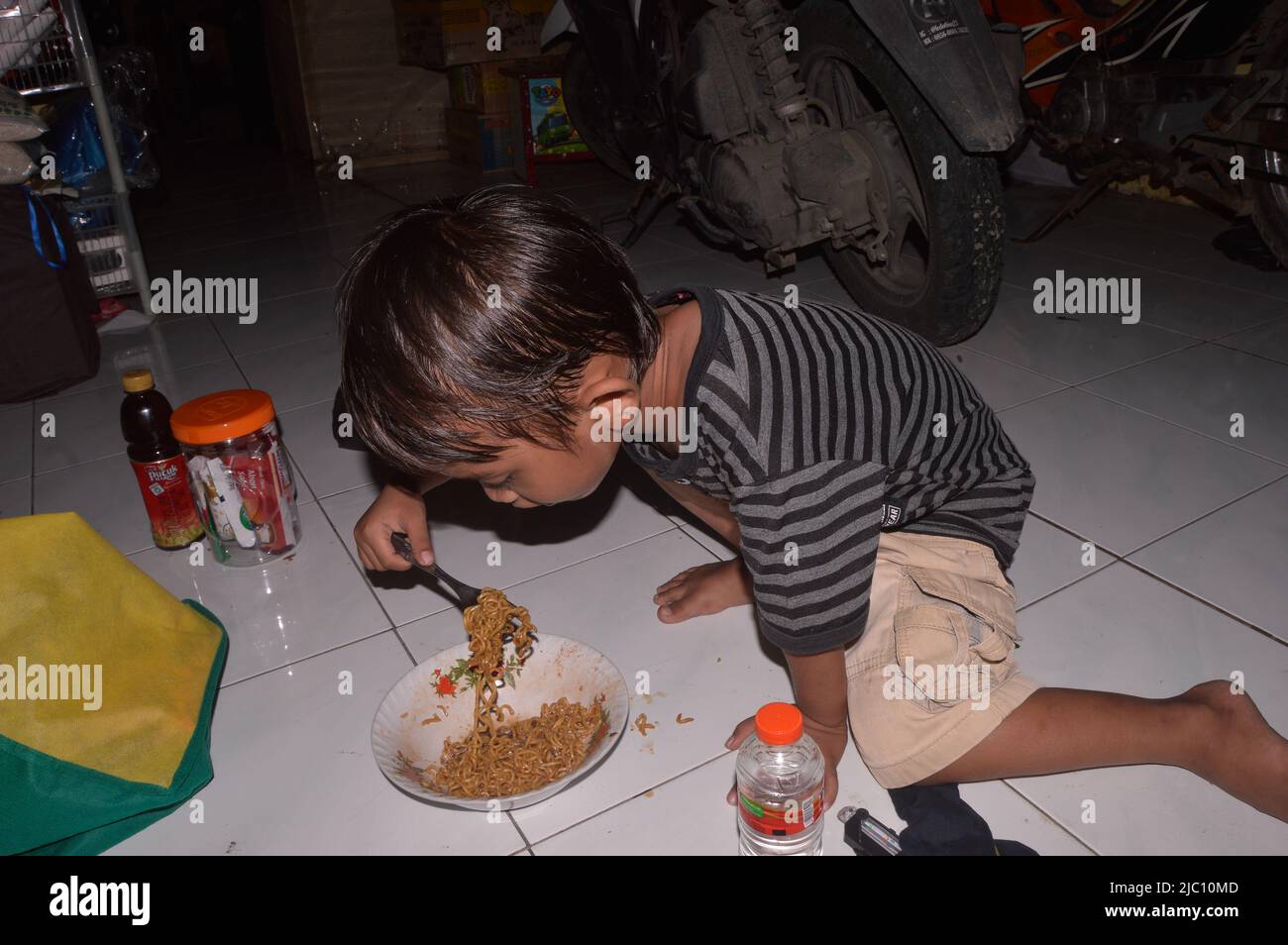 low light photo of a boy eating at home Stock Photo - Alamy