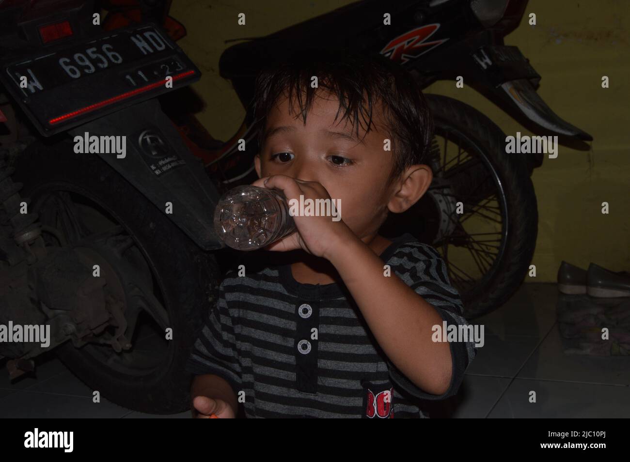 a boy drinking with his left hand Stock Photo - Alamy
