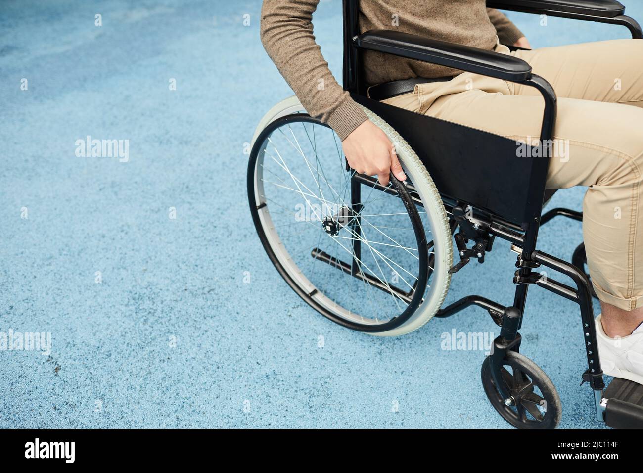 Close-up of unrecognizable paralyzed man in casual outfit using ...