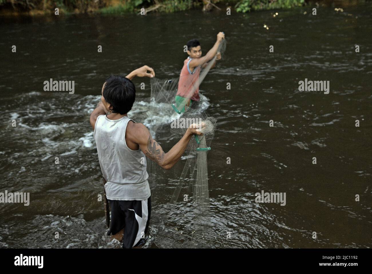 Men using fishing net on a river in Sungai Utik, Batu Lintang, Embaloh ...