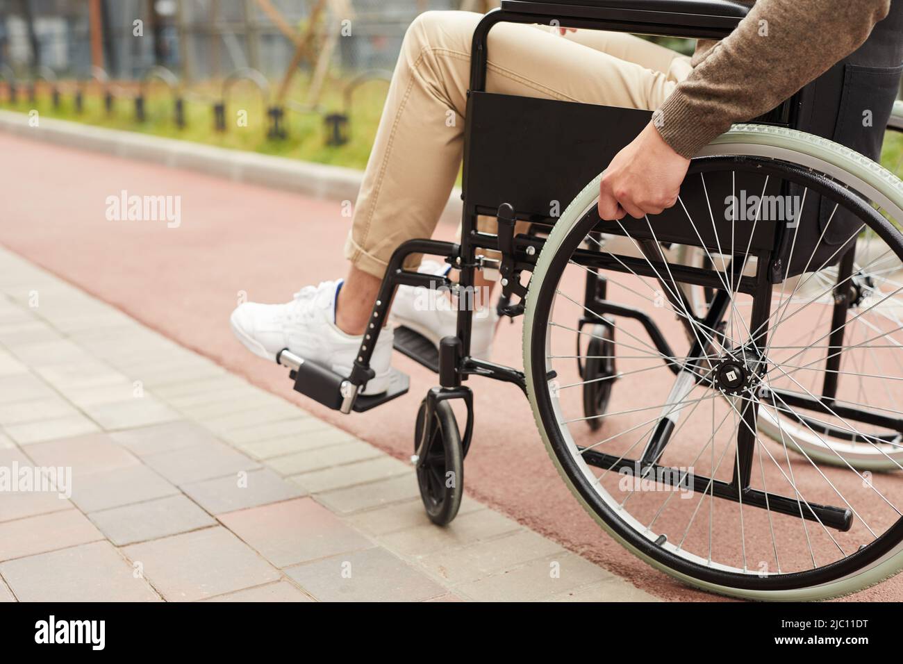 Close-up of unrecognizable man in beige jeans having difficult to walk ...
