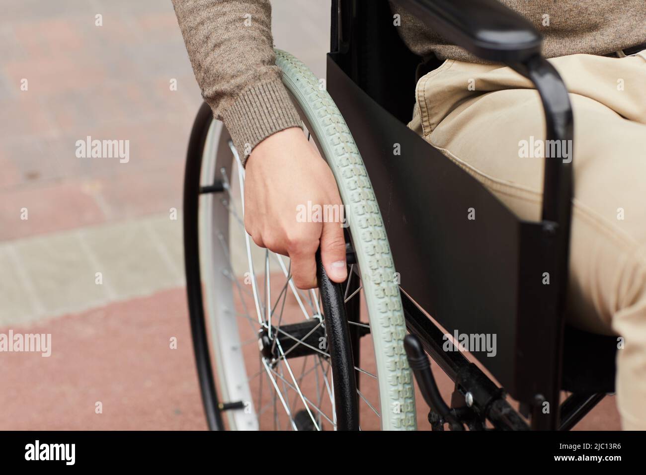 Close-up of unrecognizable man practicing ride in modern wheelchair ...