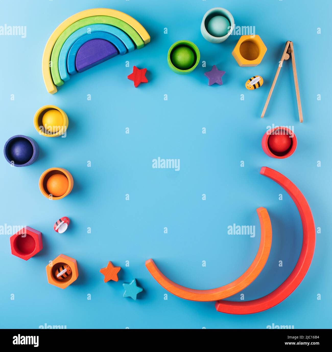 Frame made of wooden educational toys on a blue background with space ...
