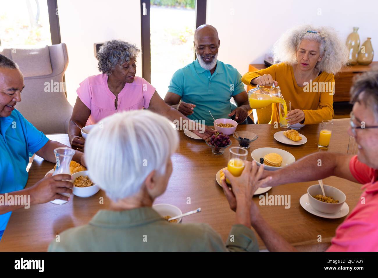 High angle view of multiracial senior friends having breakfast on ...