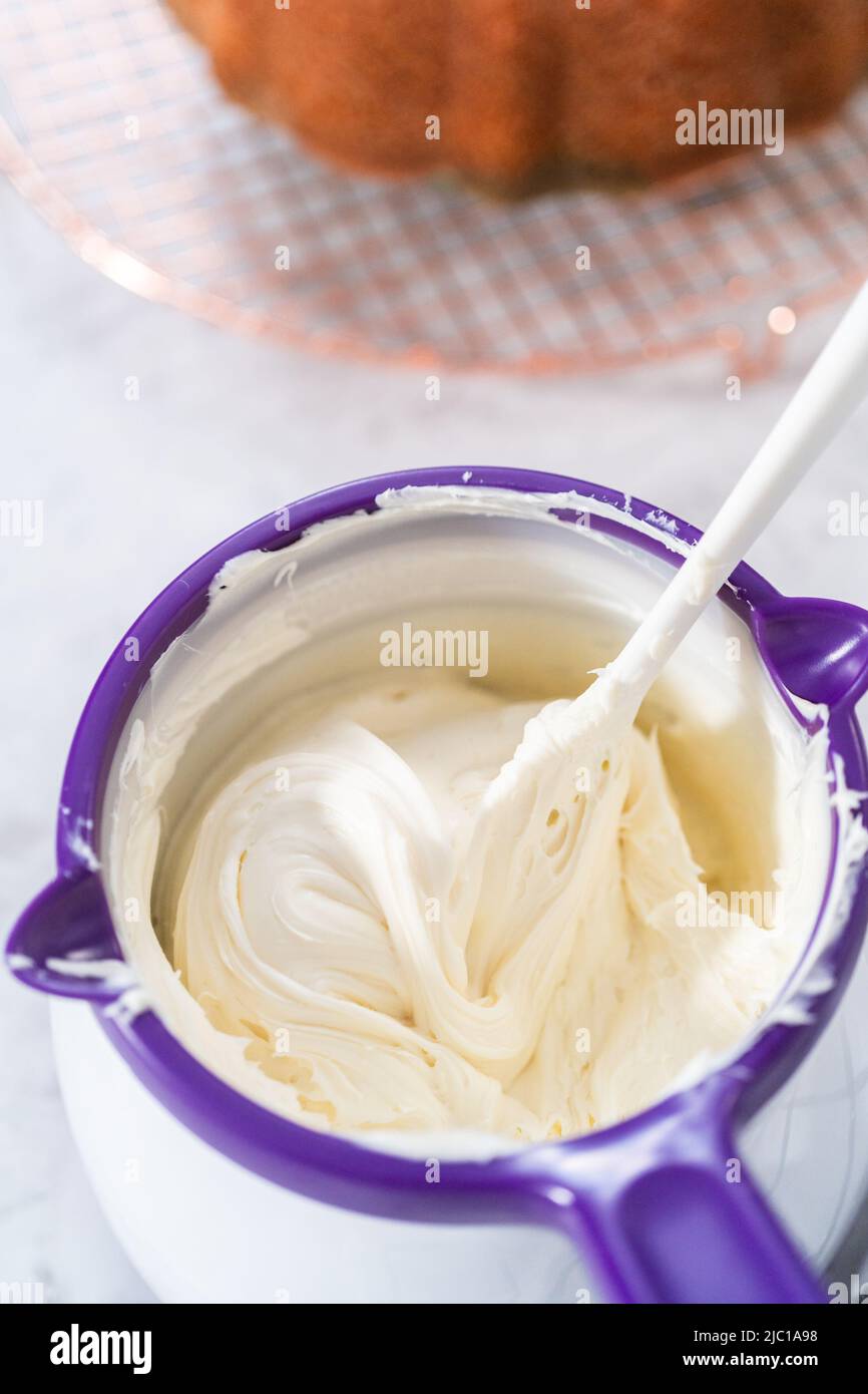 Melting store-bought buttercream frosting in candy melting pot to glaze ...