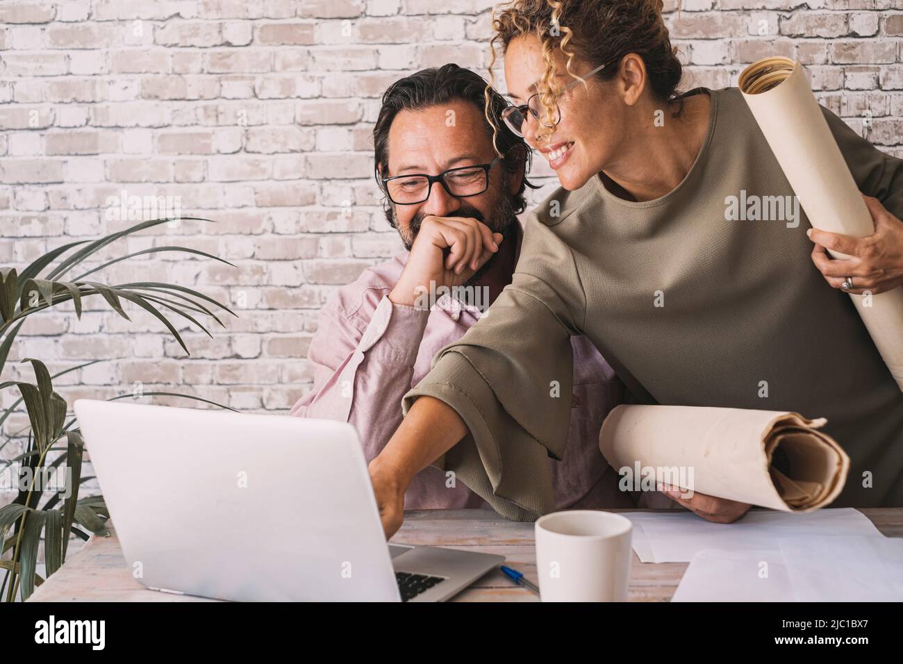 Happy couple of adult worker smile and enjoy job together. Woman ...