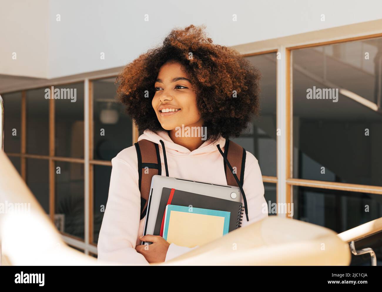 Smiling girl climbing college stairs. Student in university moving up ...