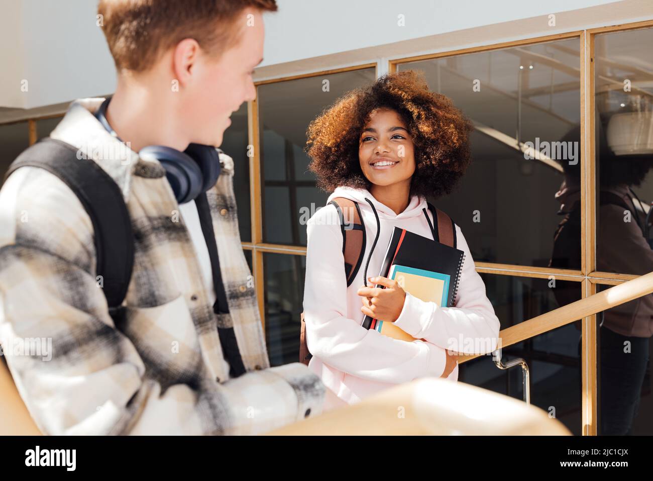 Two classmates looking at each other while climbing college stairs ...