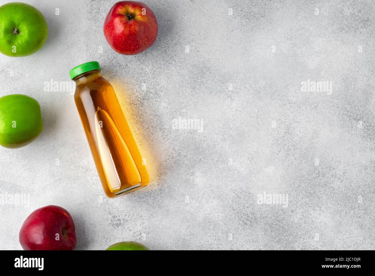 Apple juice in glass bottle with apples on table Stock Photo - Alamy