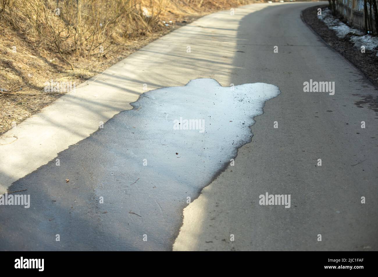Puddle on asphalt. Wet road. Spilled water on pedestrian zone. Big ...