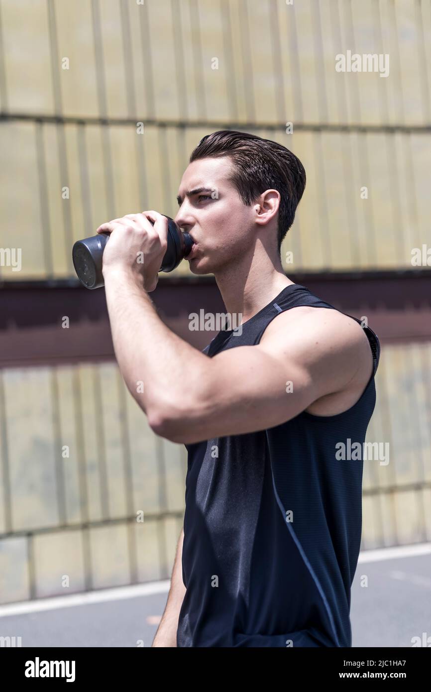 Muscular young male drinking water after workout Stock Photo - Alamy