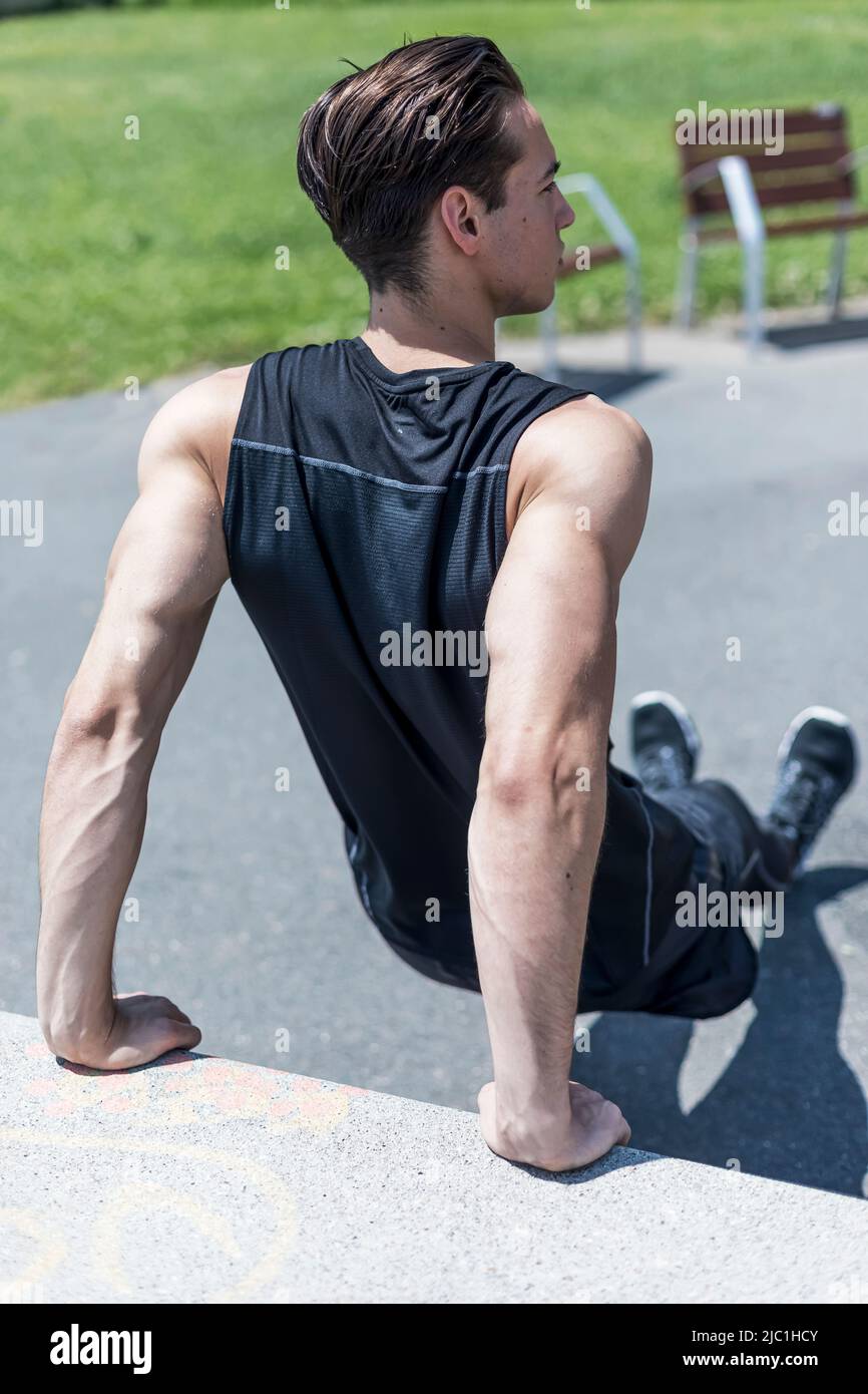 Fitness man doing bench triceps dips during outdoor cross training ...