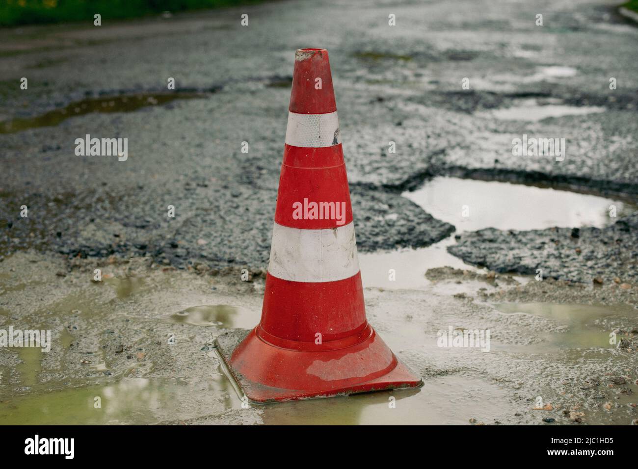 Warning about hole in road. Signal cap on asphalt. Triangle of orange ...