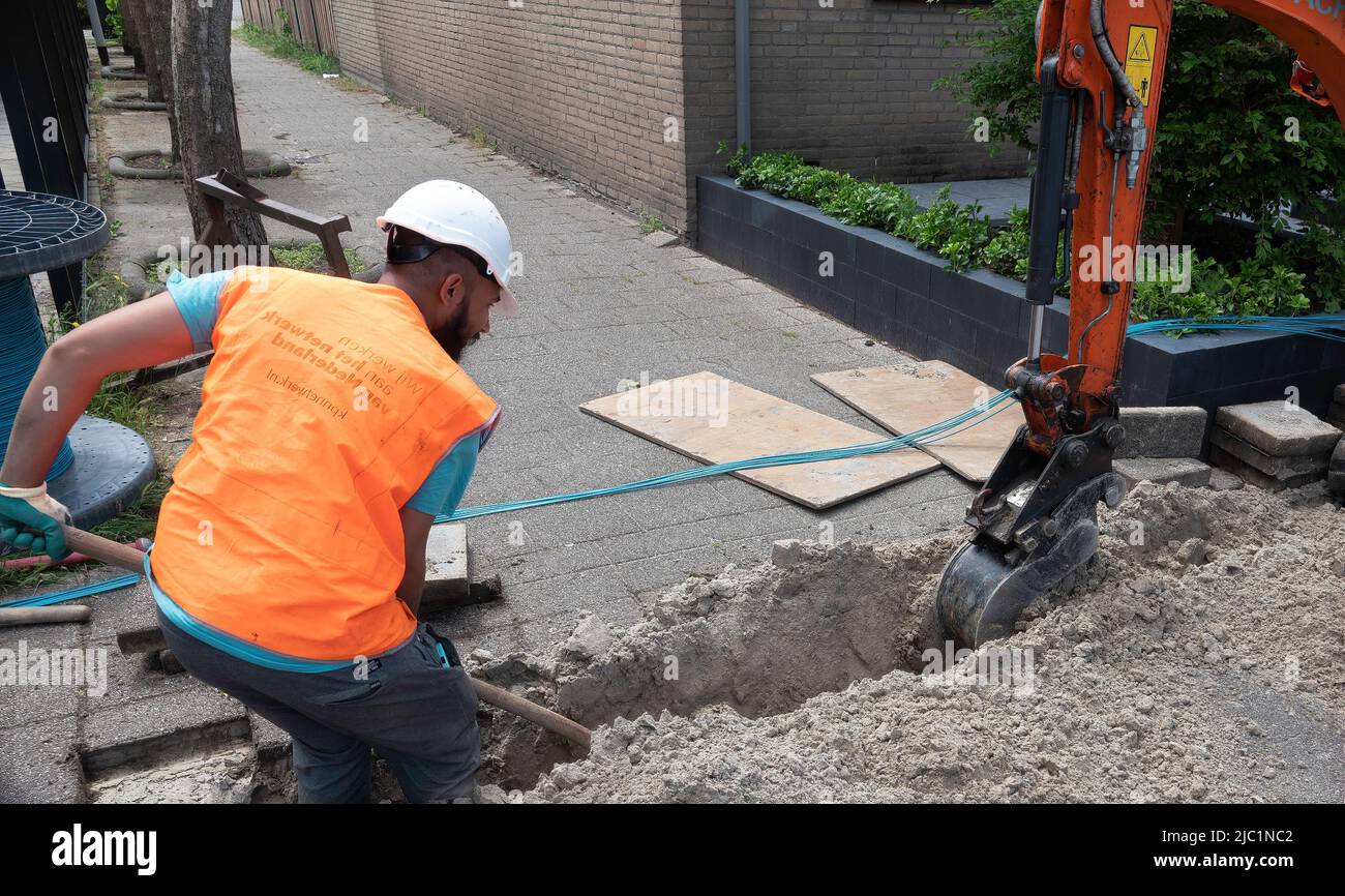 man digging a trench for the construction of fiber optic Stock Photo ...