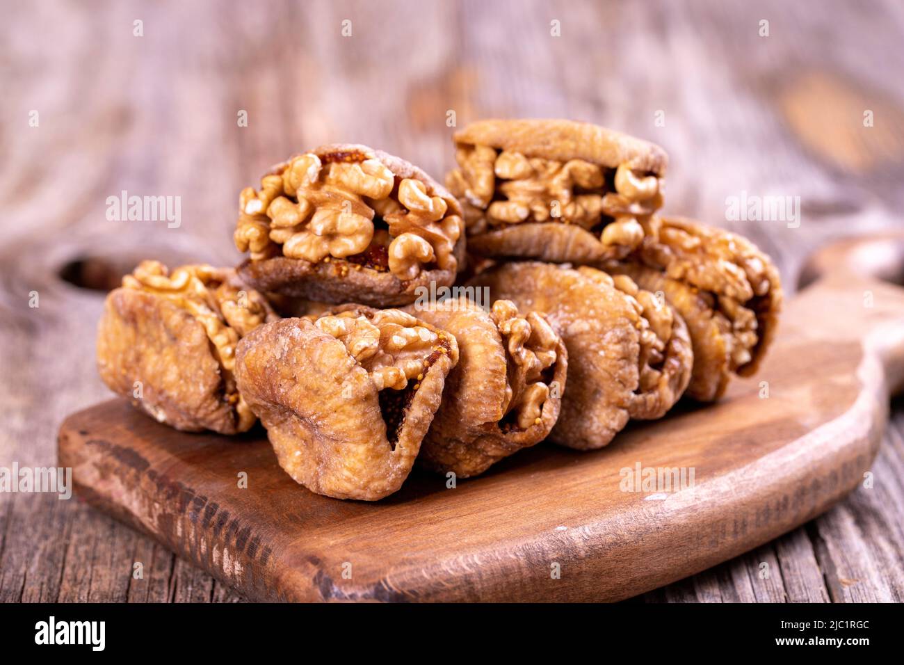 Stuffed dried figs. Dried figs stuffed with walnuts on a wood floor ...