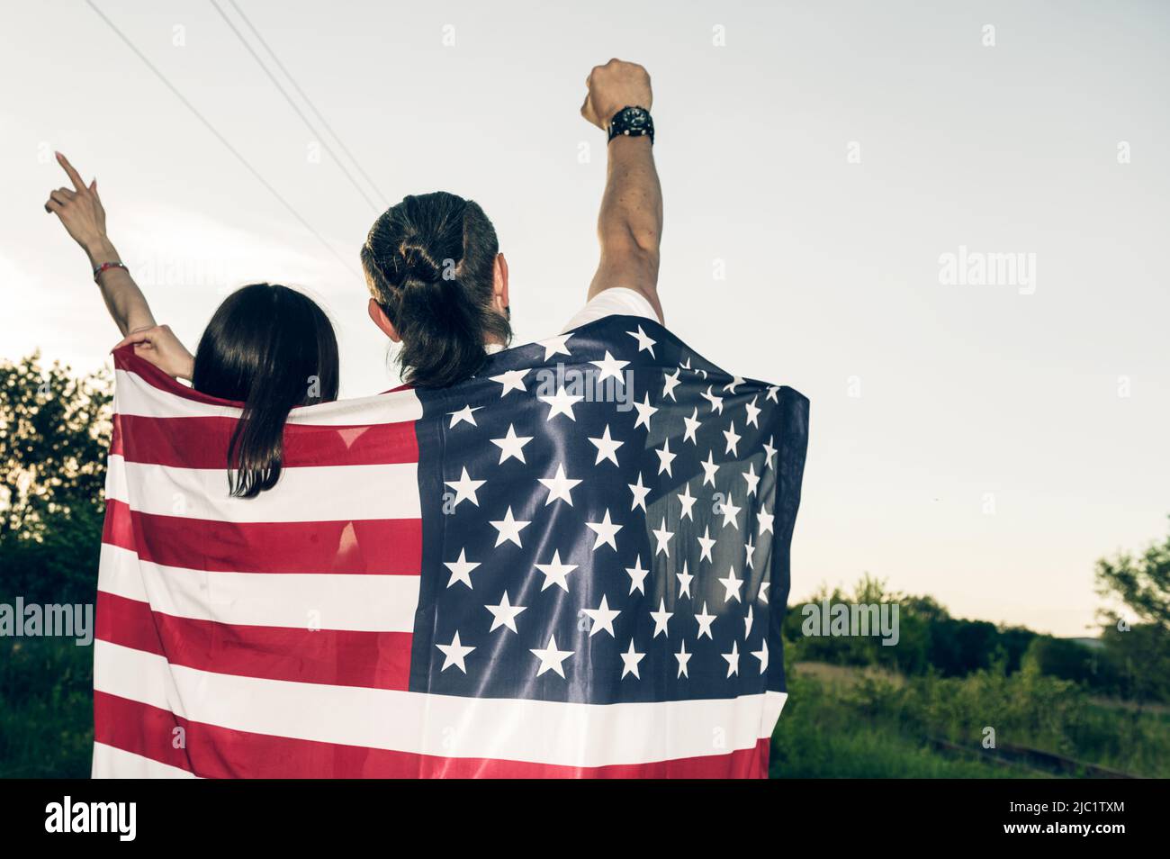 Back view of man and woman holding american flag outdoor Stock Photo ...