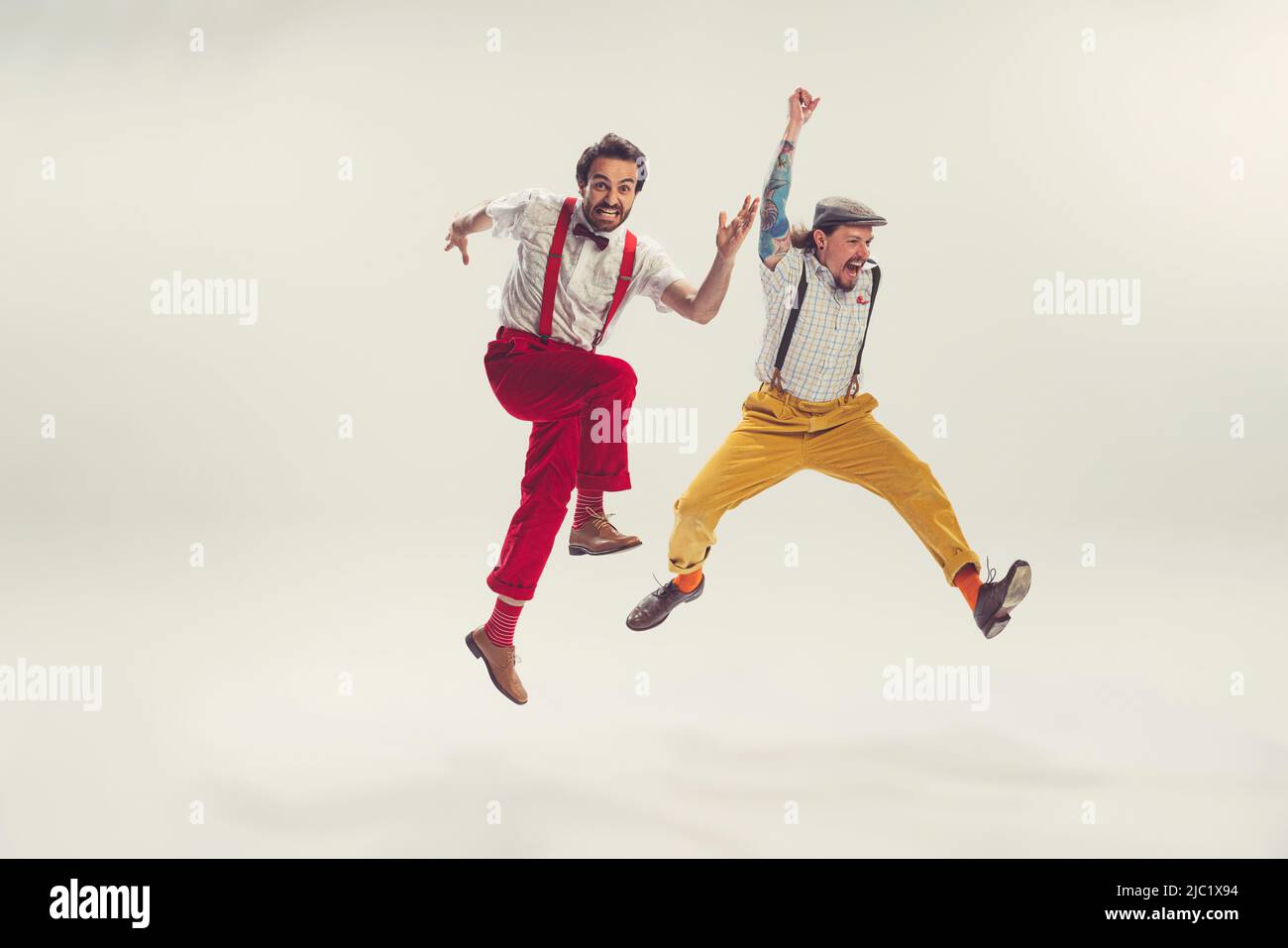 Two cheerfull dudes, young men in old-school fashioned attire running ...