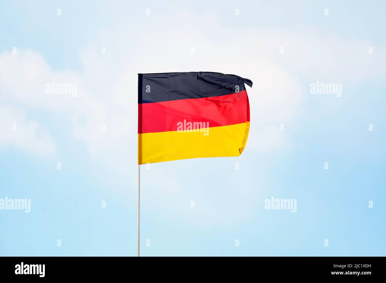 Germany flag on cloudy sky background. close up waving flag of Germany ...