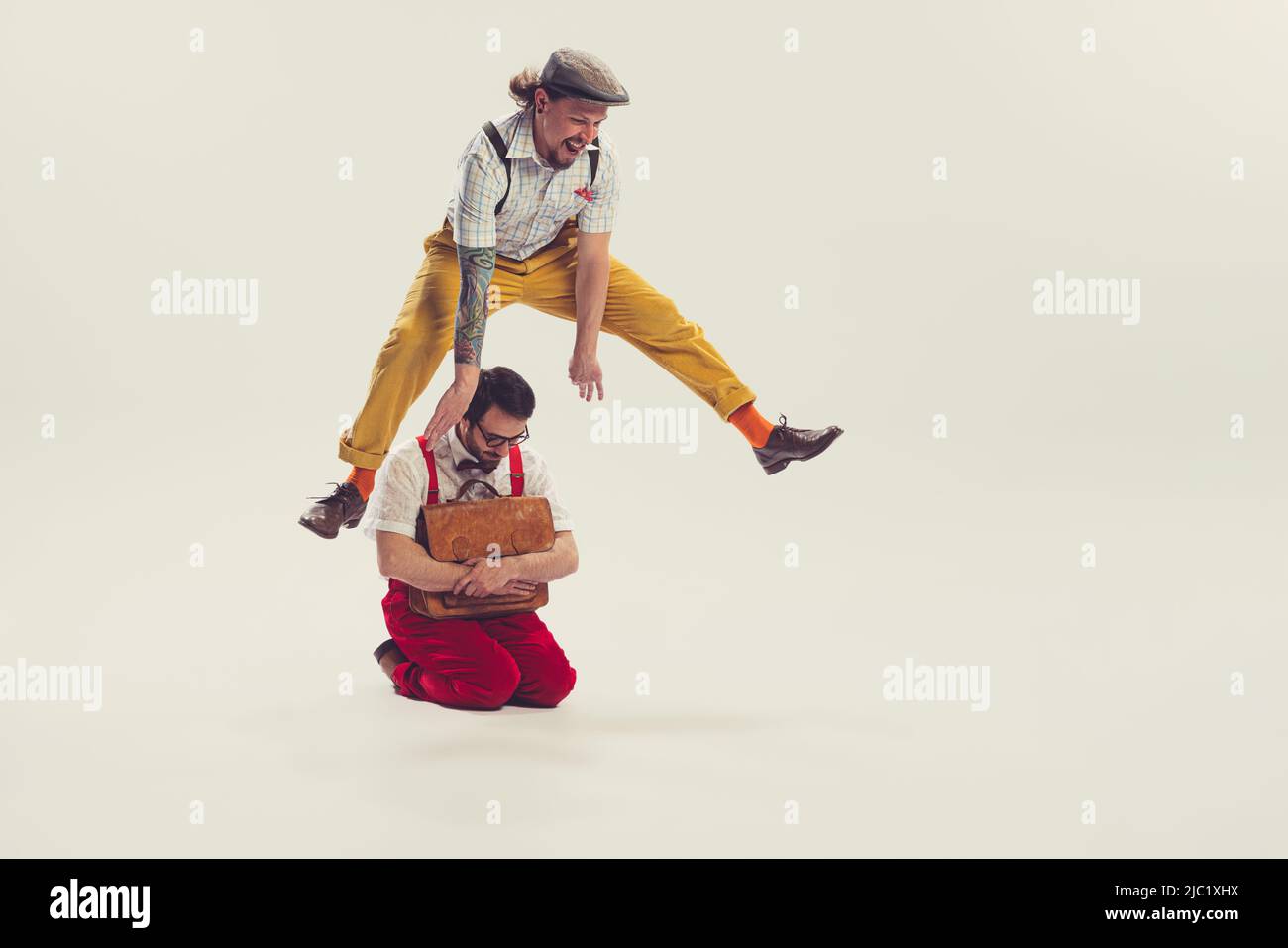 Two cheerfull dudes, young men in old-school fashioned attire running ...