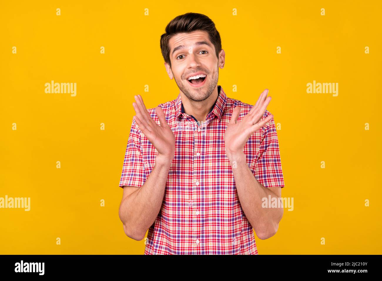 Portrait of attractive delighted cheerful brunette guy clapping palms ...