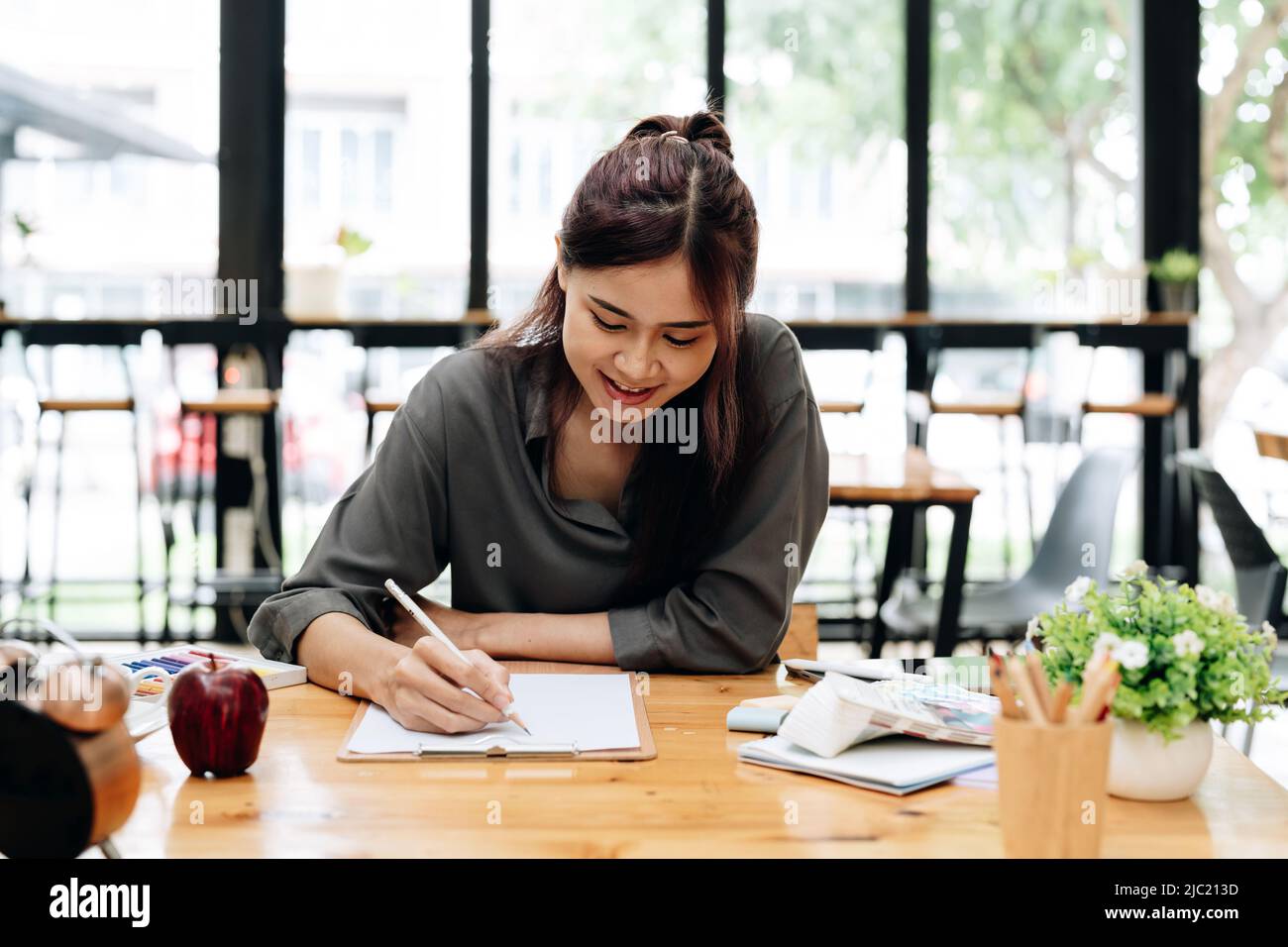 Pretty smiling young woman drawing a picture. Smiling young woman draw ...