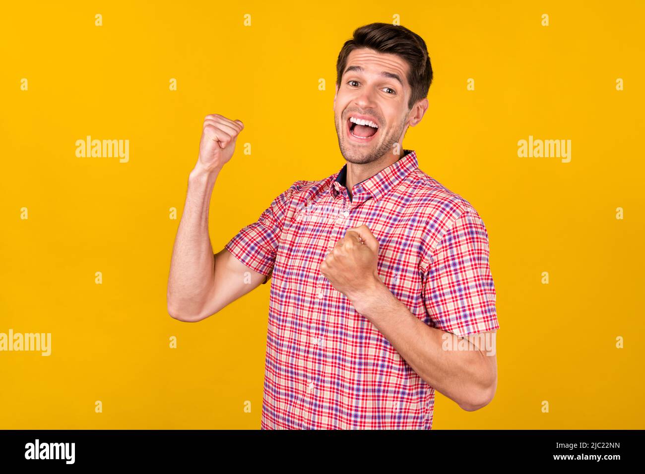 Photo of cheerful happy positive young man raise fists winner celebrate ...