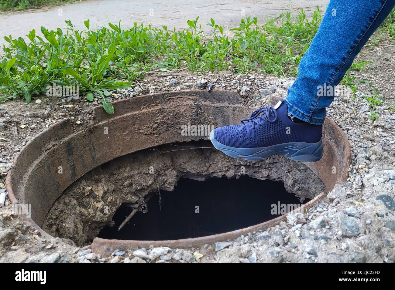 A man's foot is on an open sewer hatch, Danger concept city Stock Photo ...