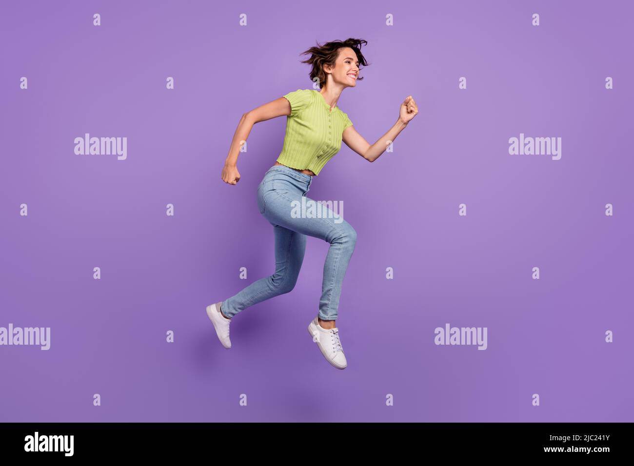 Photo of positive funky young woman dressed green t-shirt jumping high ...